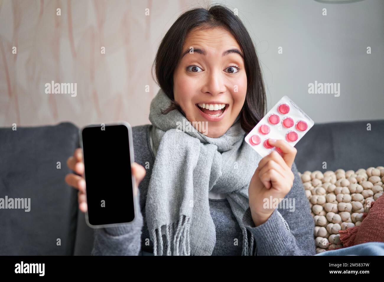 Online doctors and healthcare. Smiling korean woman shows mobile phone ...