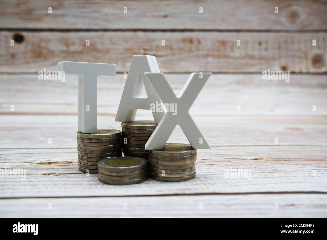 TAX alphabet letters with coin stack on wooden background Stock Photo ...