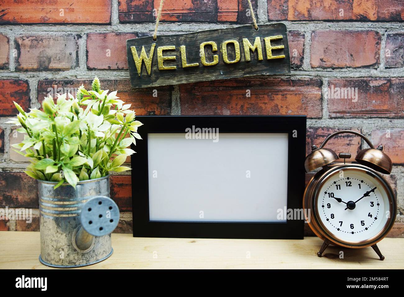 Empty photo frame mock up with welcome sign and artficial plant home ...
