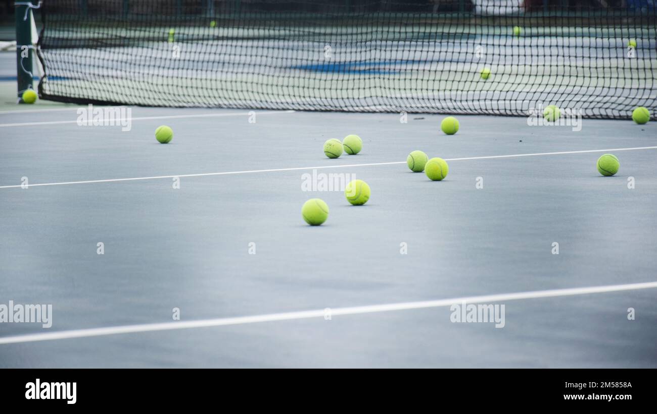 ground court with net and many yellow tennis balls Stock Photo - Alamy