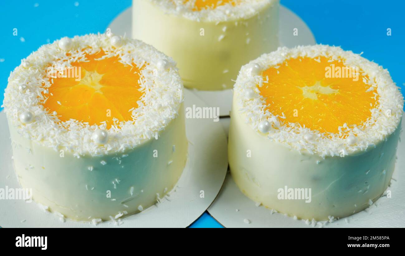 Small cakes with orange and coconut on a blue background Stock Photo ...