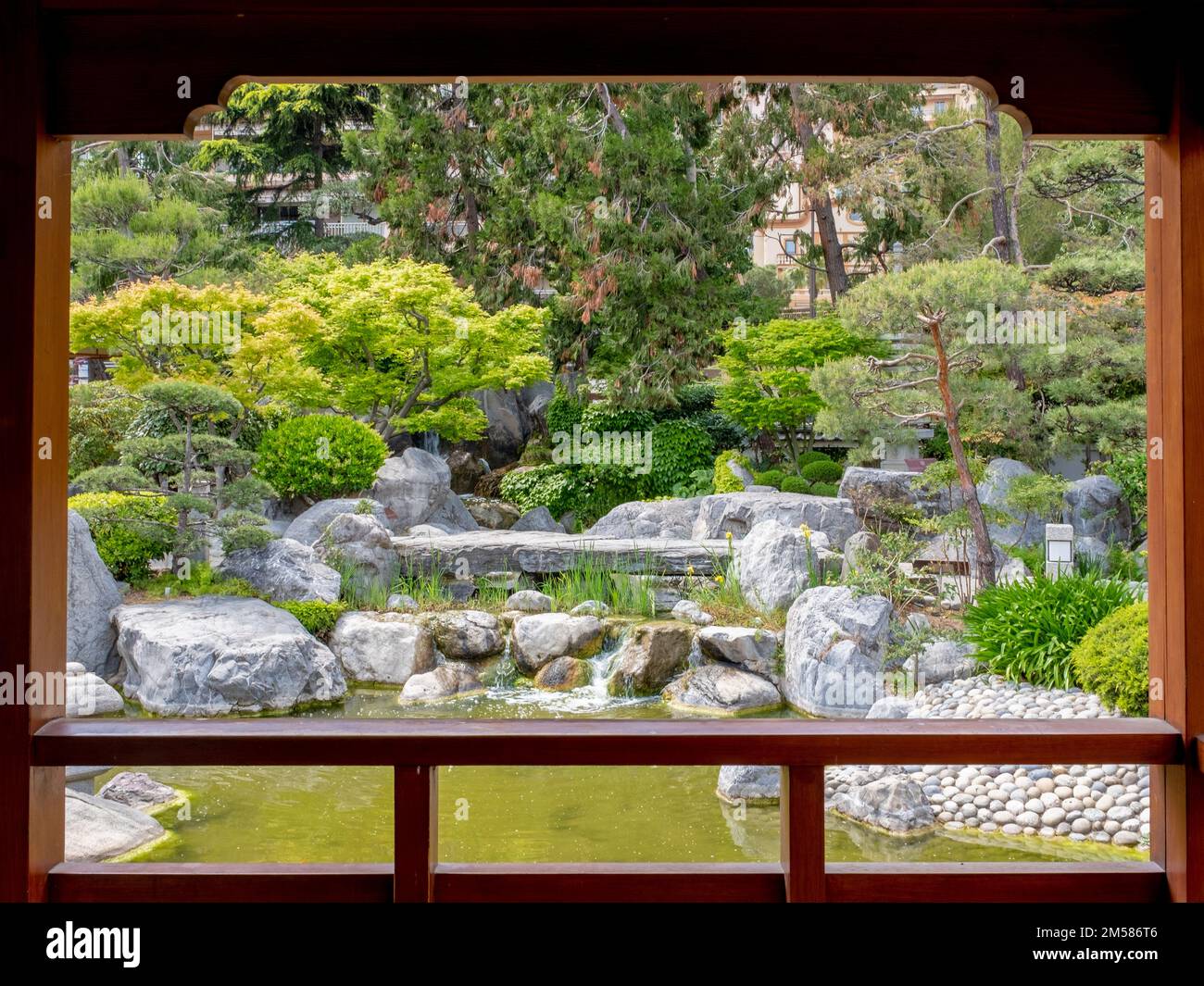 Monaco - May 3, 2022: A pond and a waterfall seen from a wood pavilion of the Japanese garden of ...