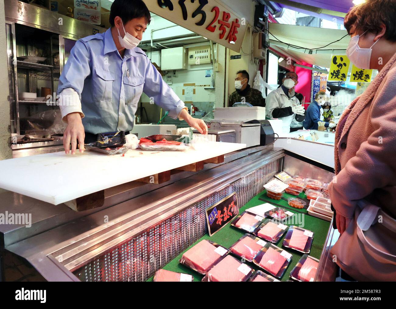Tokyo, Japan. 27th Dec, 2022. A year-end shopper buys a block of tuna ...