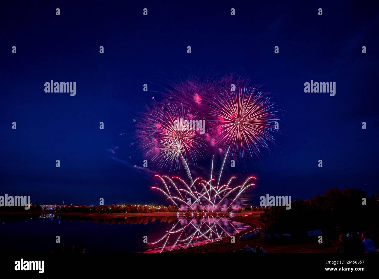 Colorful fireworks in a distance at night city by water Stock Photo - Alamy