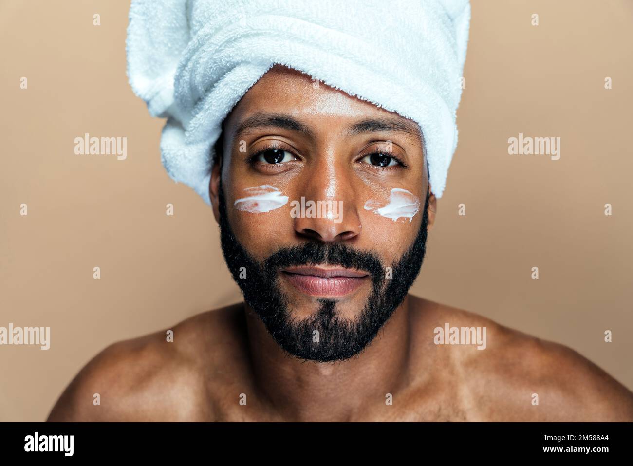Image of a young man taking care of his skin. Beauty studio shot about ...