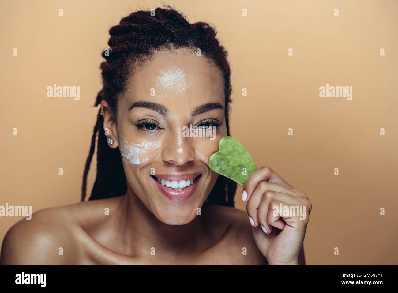 Beautiful woman making skin and facial beauty treatments. Studio shot ...