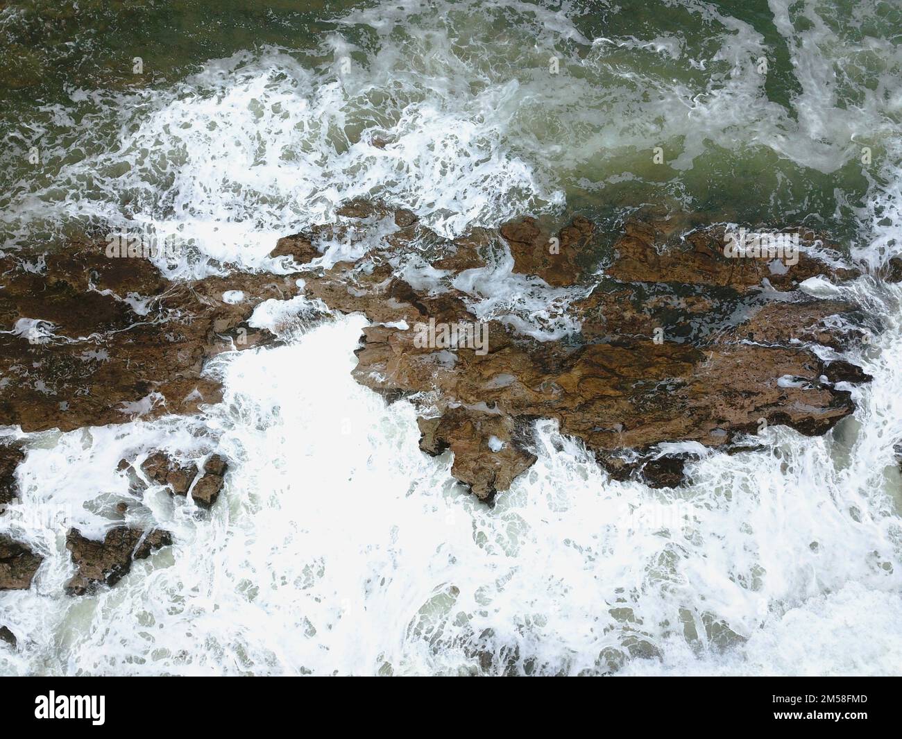 A top view of a wave splash against a rock in the coastline Stock Photo ...