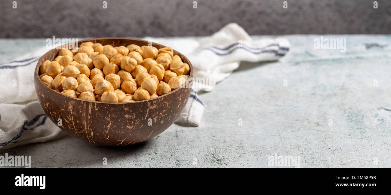 Roasted hazelnuts in bowl on gray background. Nuts in a coconut bowl ...