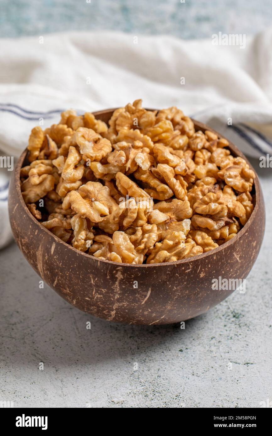 Walnuts in a bowl on a gray background. Walnuts in a coconut bowl ...