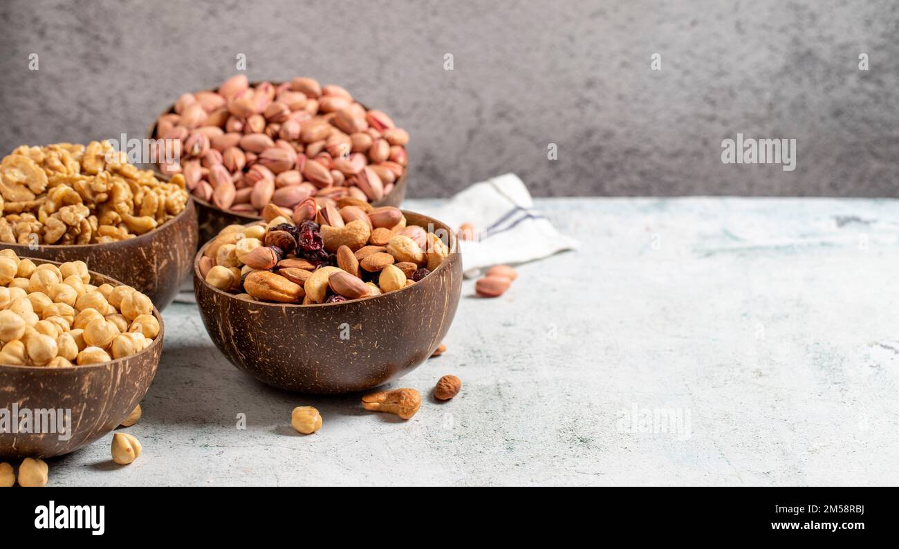 Walnuts, pistachios, hazelnuts and mixed nuts in a bowl on a gray ...