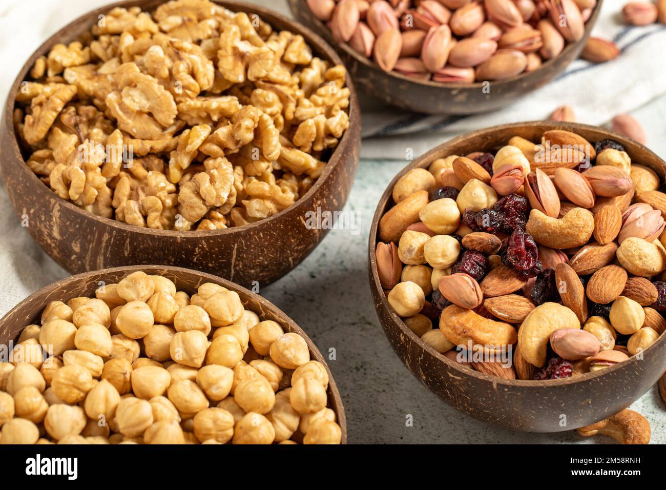 Walnuts, pistachios, hazelnuts and mixed nuts in a bowl on a gray ...