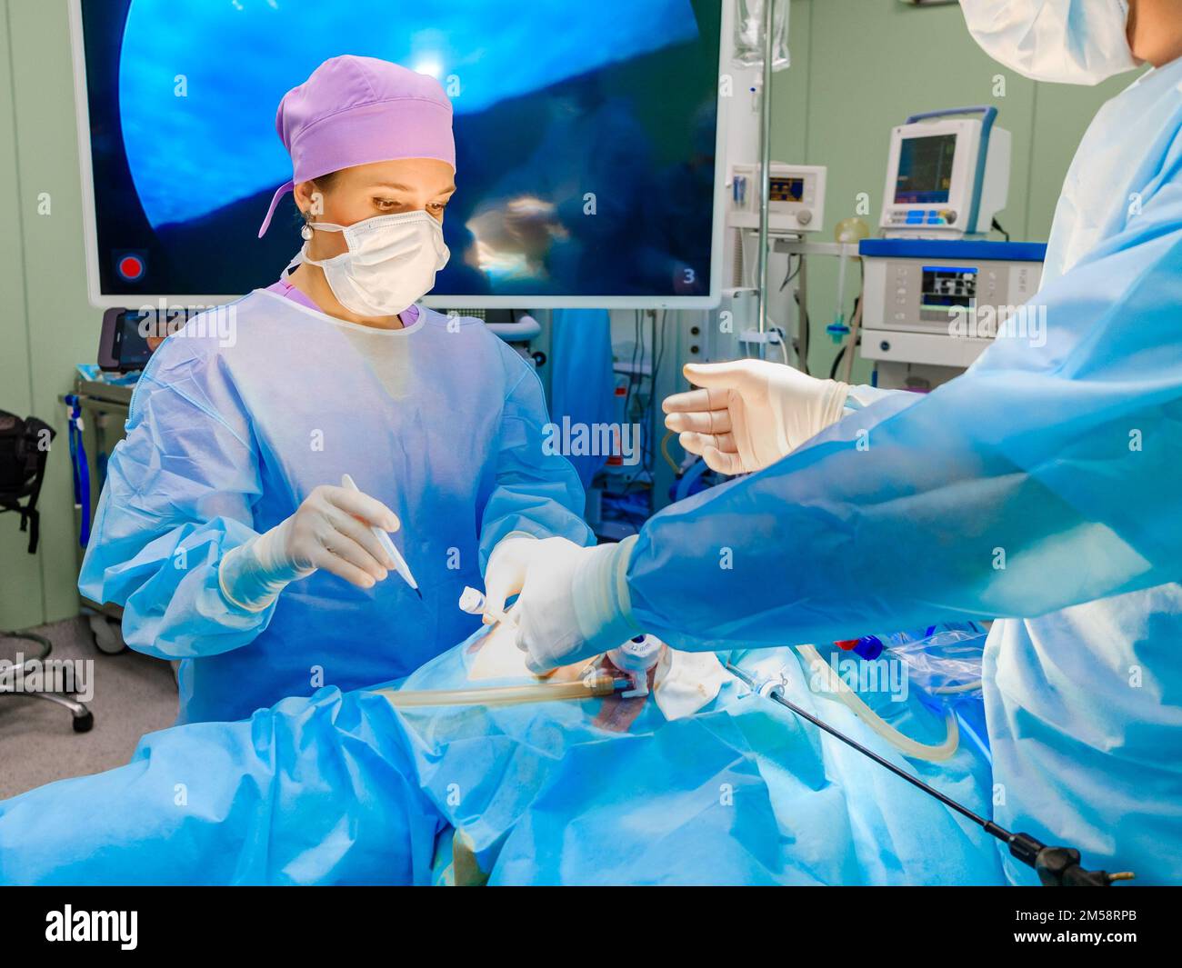 A female doctor with a scalpel performs surgery in the interior of the ...