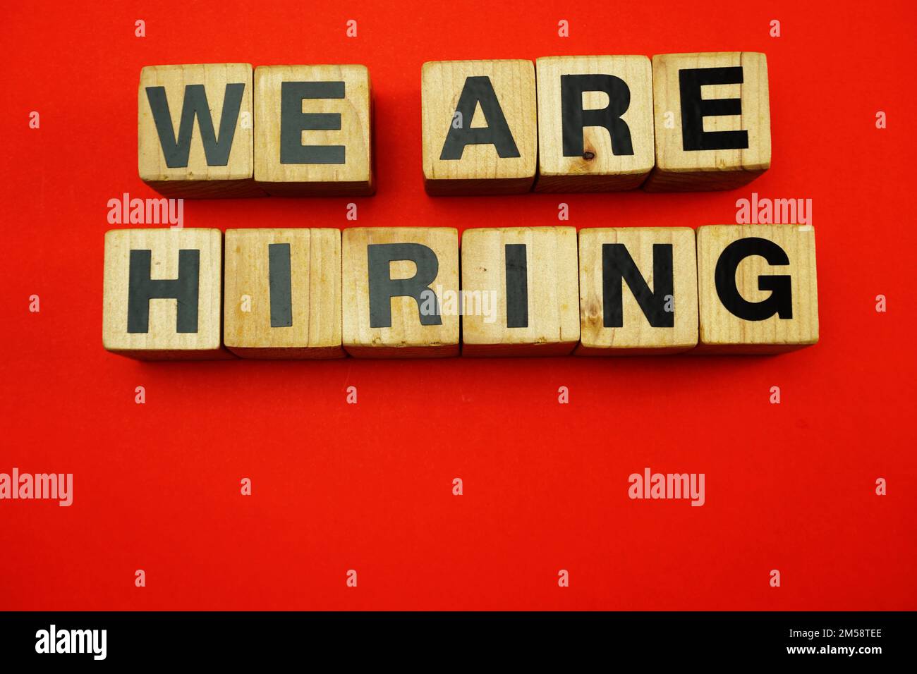 We are Hiring word created with cubes alphabet letters on red ...