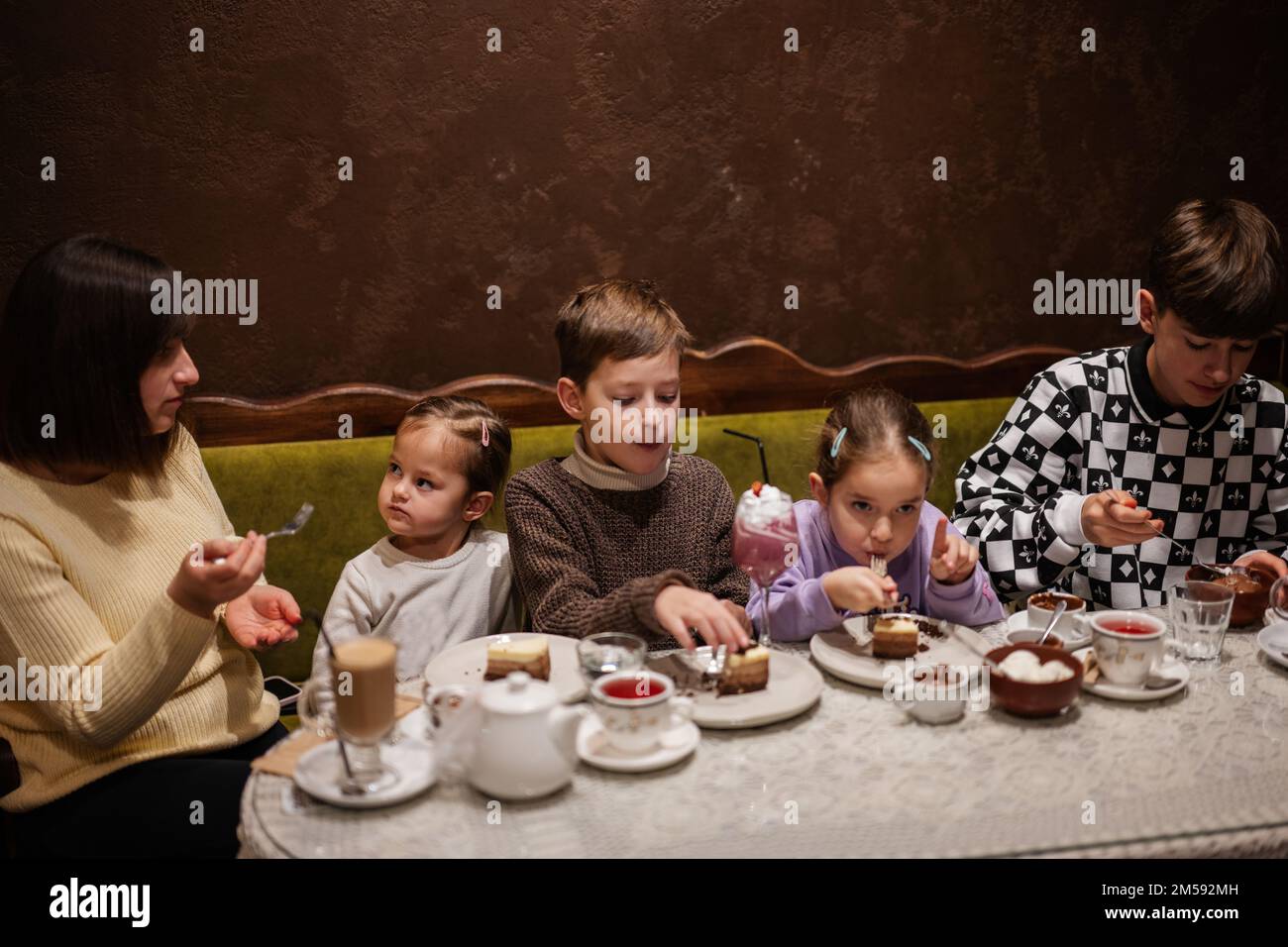 Happy family eating desserts together at cozy cafe and having fun Stock ...