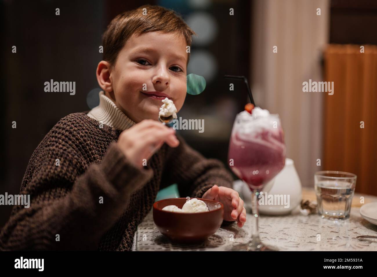 Boy eating dessert ice cream at cozy cafe and having fun Stock Photo ...