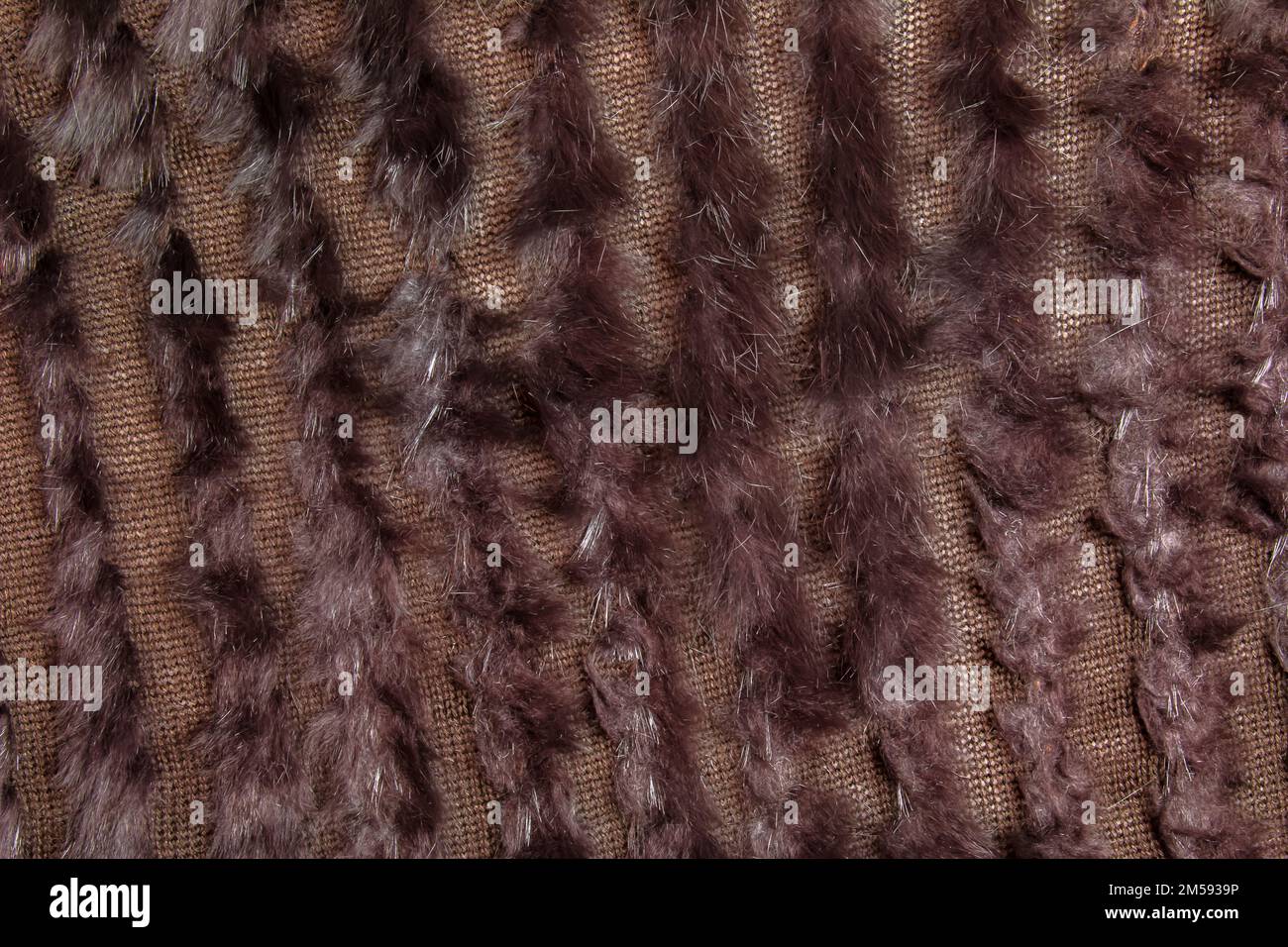 Background from dark brown fur and wool. Combined knitted fur product ...