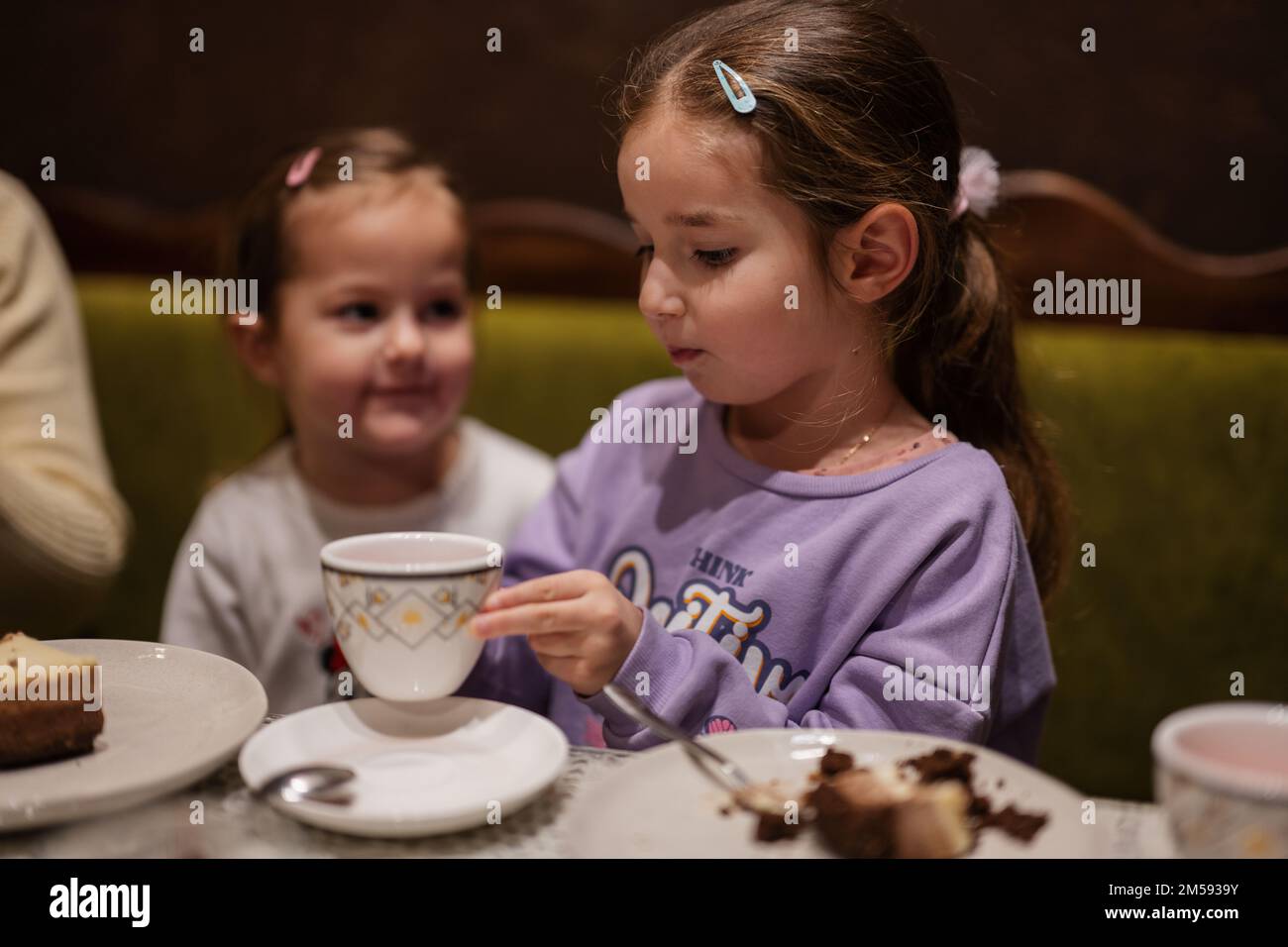 Sisters drink tea together at cozy cafe and having fun Stock Photo - Alamy