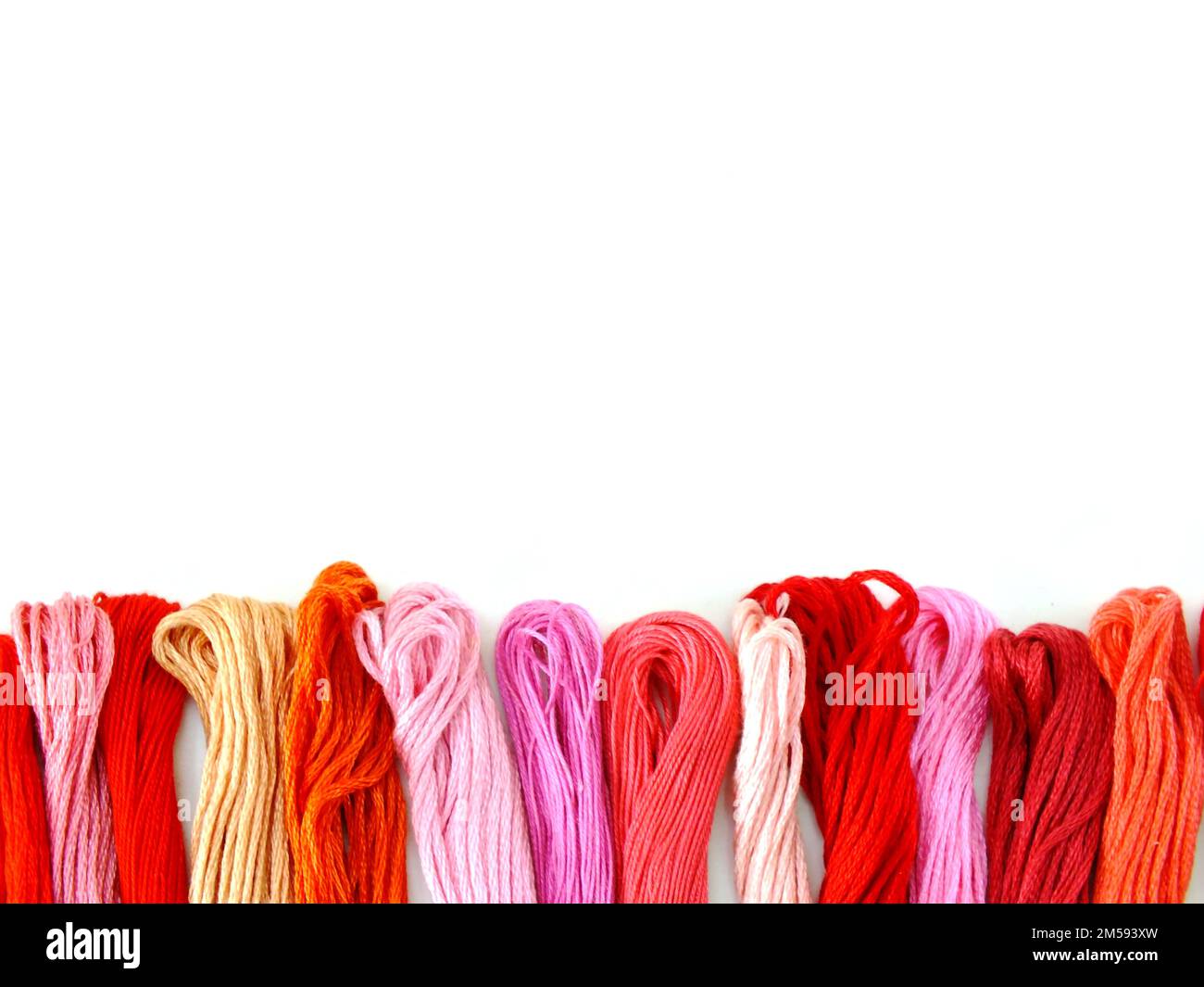 close up group of colorful spools of sewing thread top view on white ...