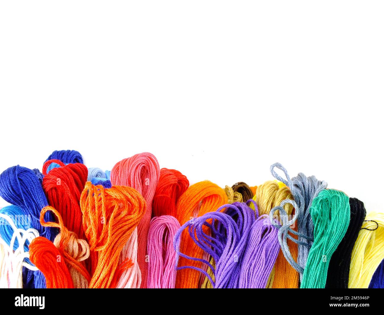 close up group of colorful spools of sewing thread top view on white ...