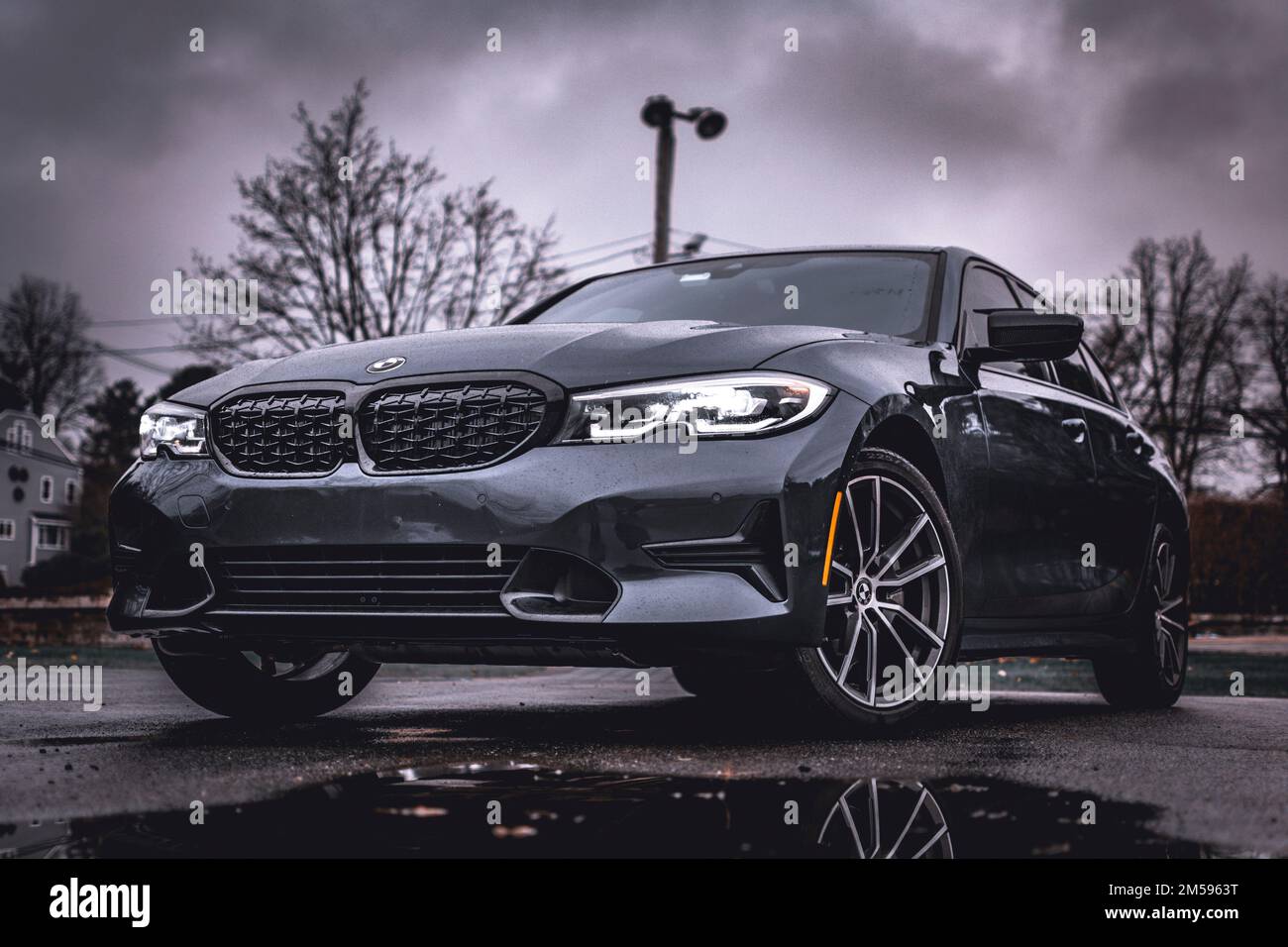 A dark metallic gray BMW 300i on the street against the background of ...