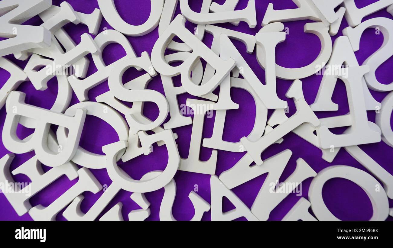 random white wooden alphabet letters top view on purple background ...