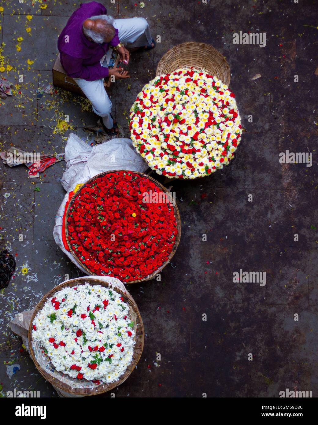 A vertical shot of a man selling rose buds in baskets Stock Photo - Alamy