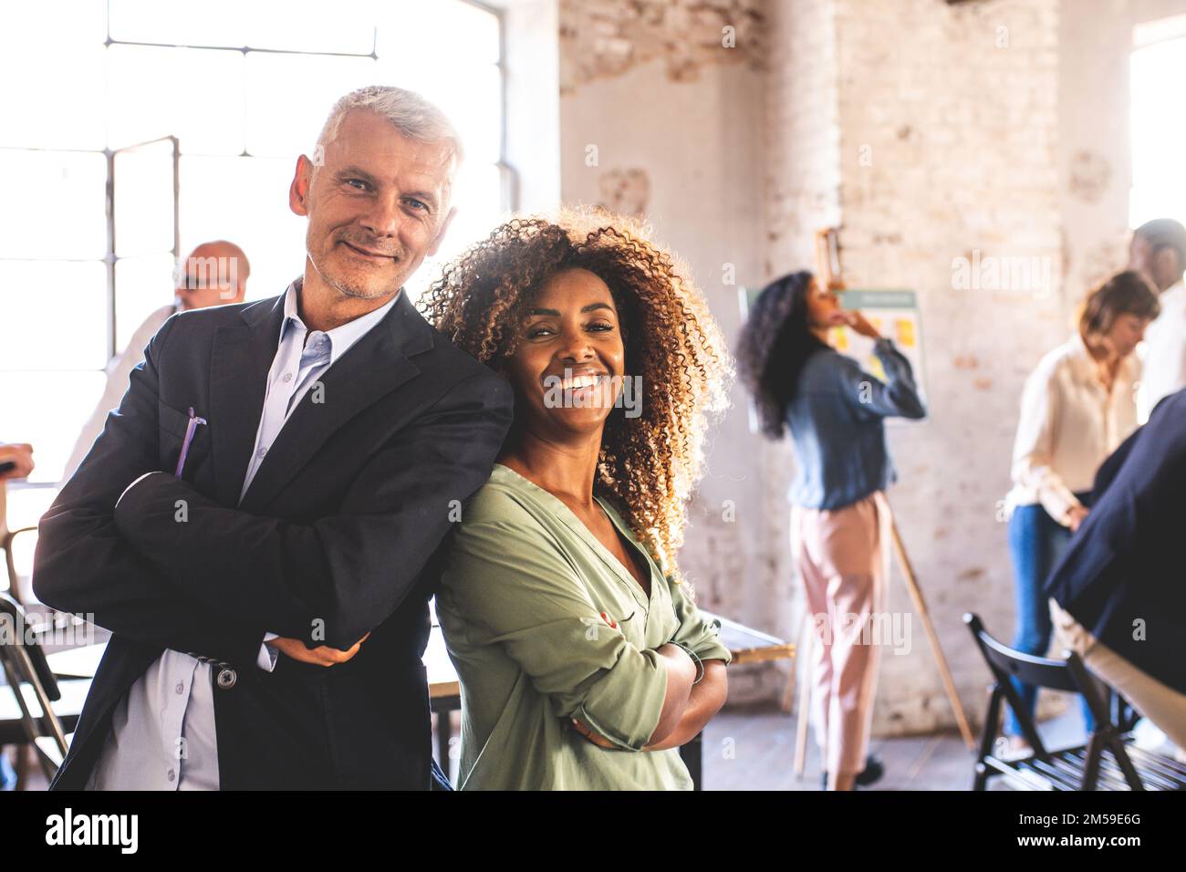 Two confident colleagues looking at the camera smiling, successfull ...