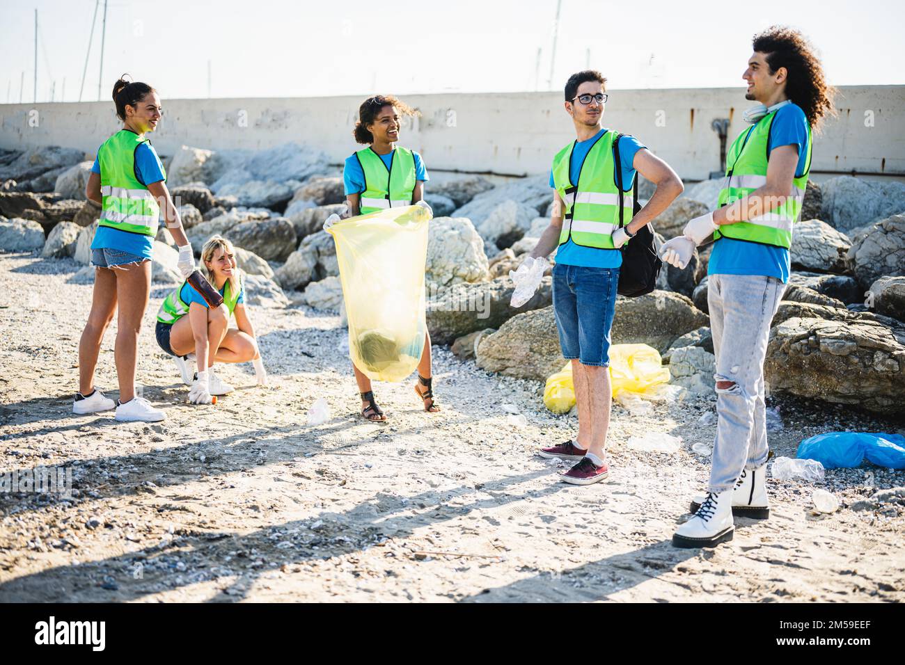 People cleaning up the beach, volunteers collecting the waste on the ...