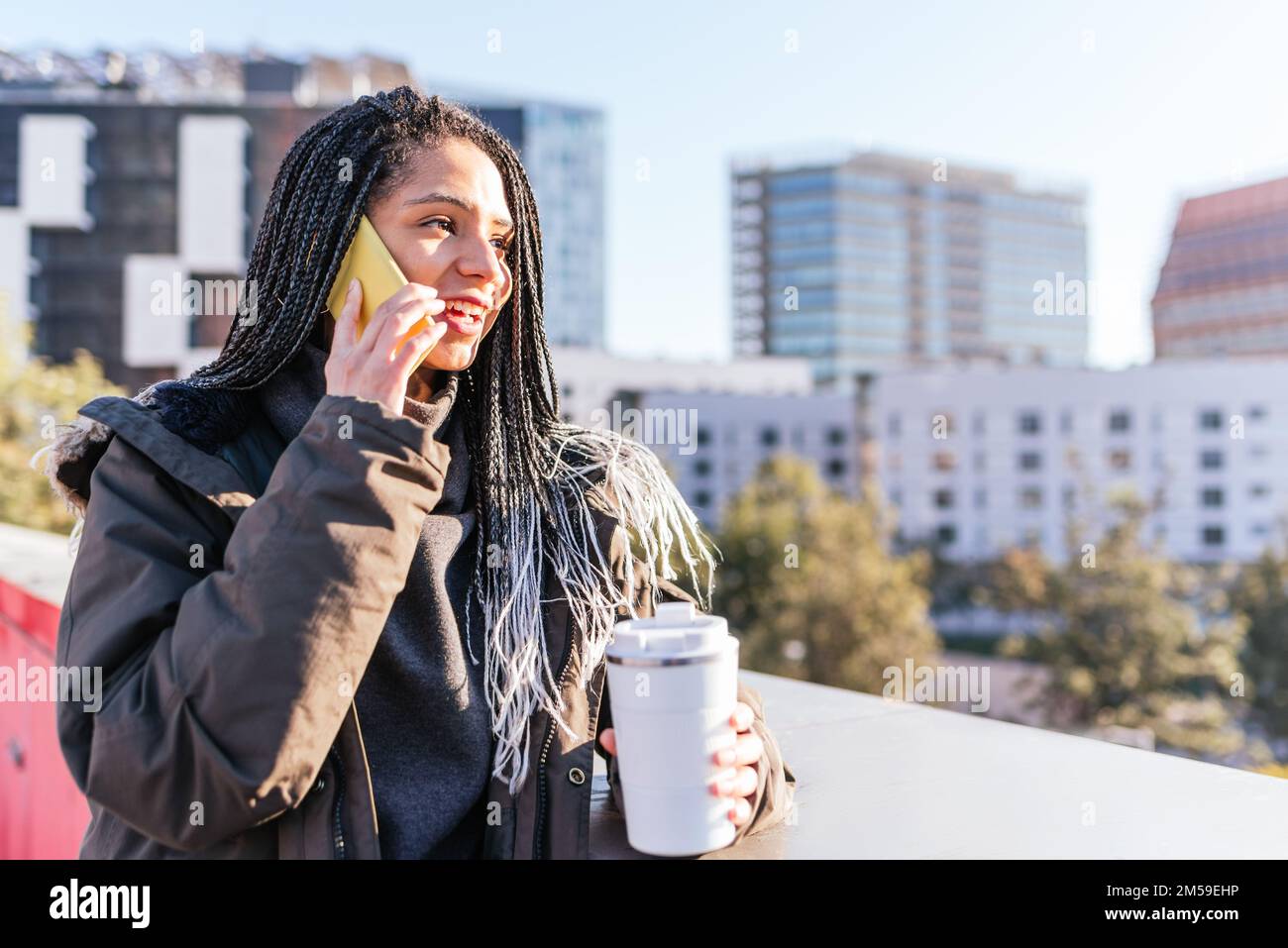 Content Hispanic female with dreadlocks having phone call while ...