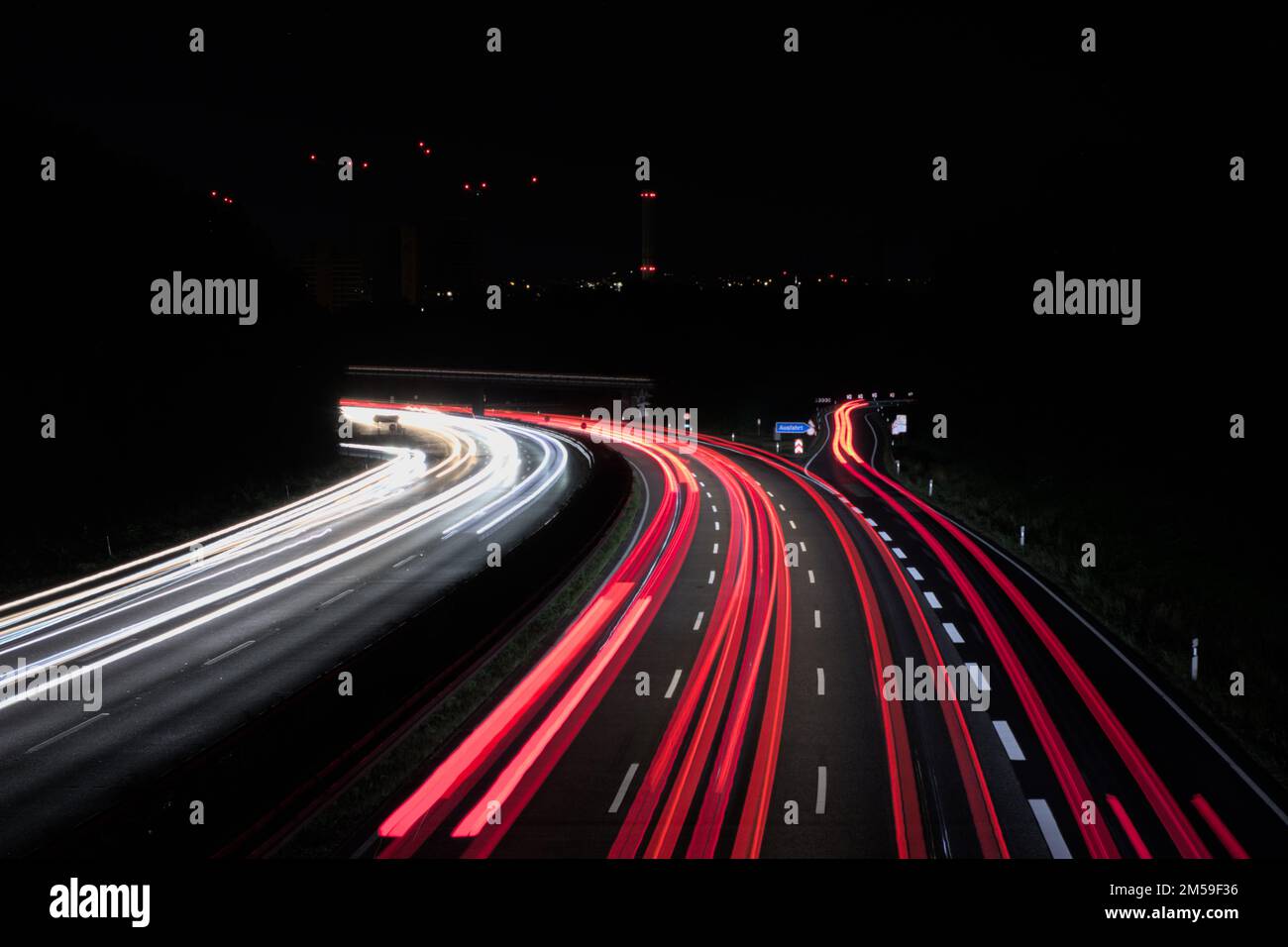 A landscape of a highway with long exposure car headlights at night ...