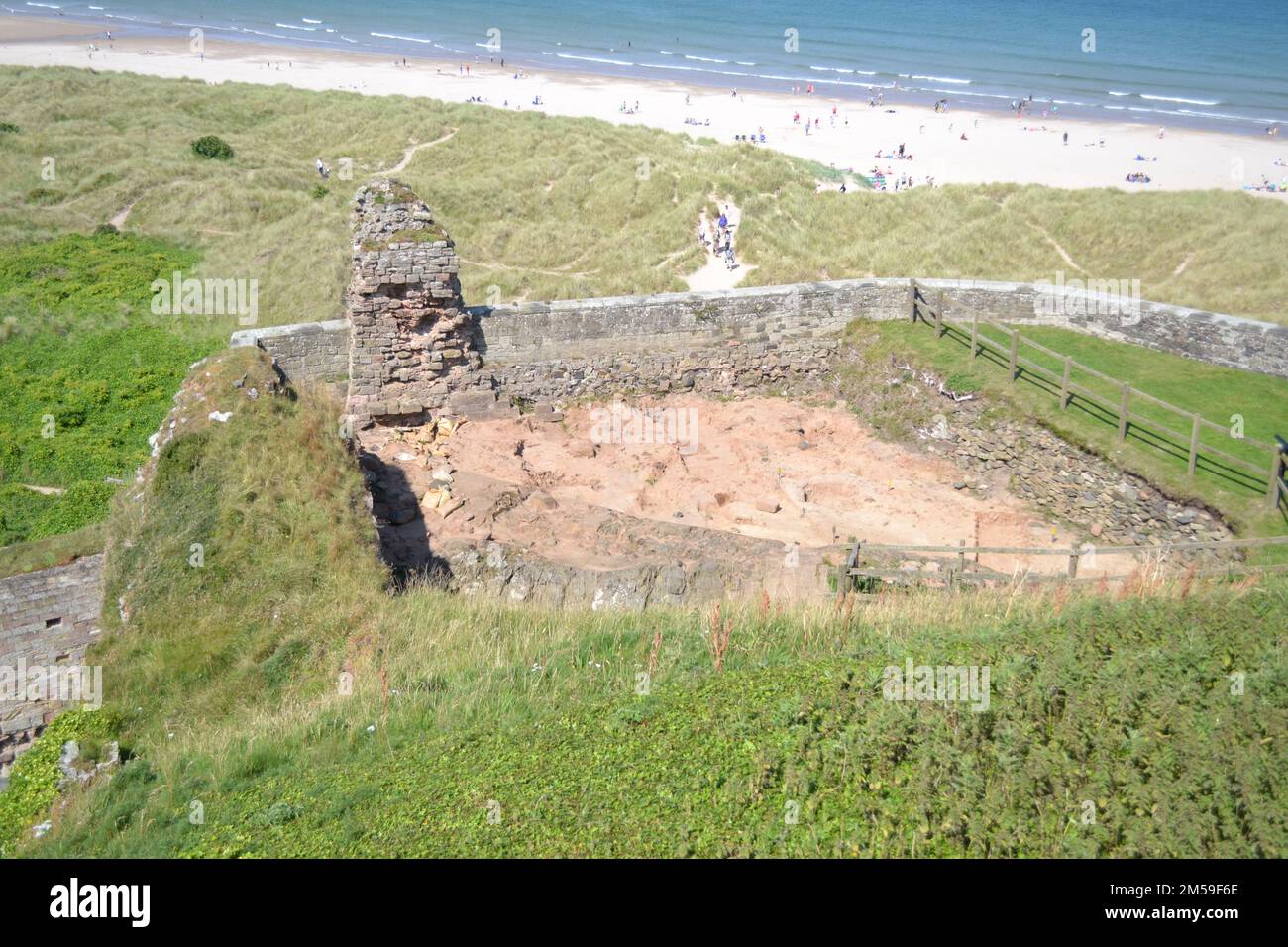 Bamburgh Castle and rocks Stock Photo - Alamy