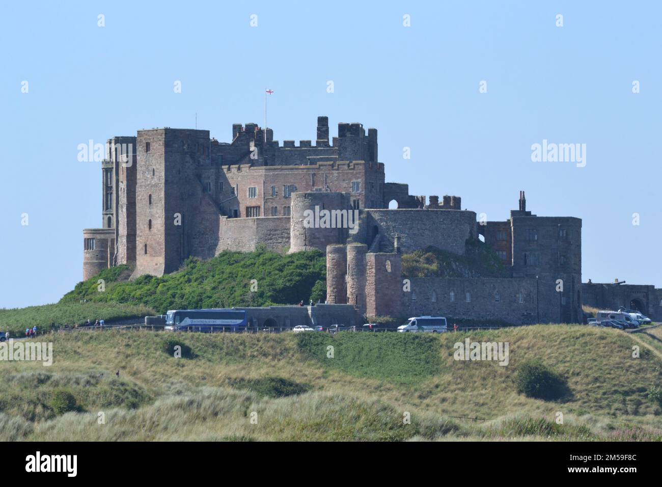 Bamburgh Castle and rocks Stock Photo - Alamy