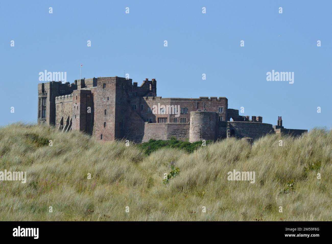 Bamburgh Castle and rocks Stock Photo - Alamy