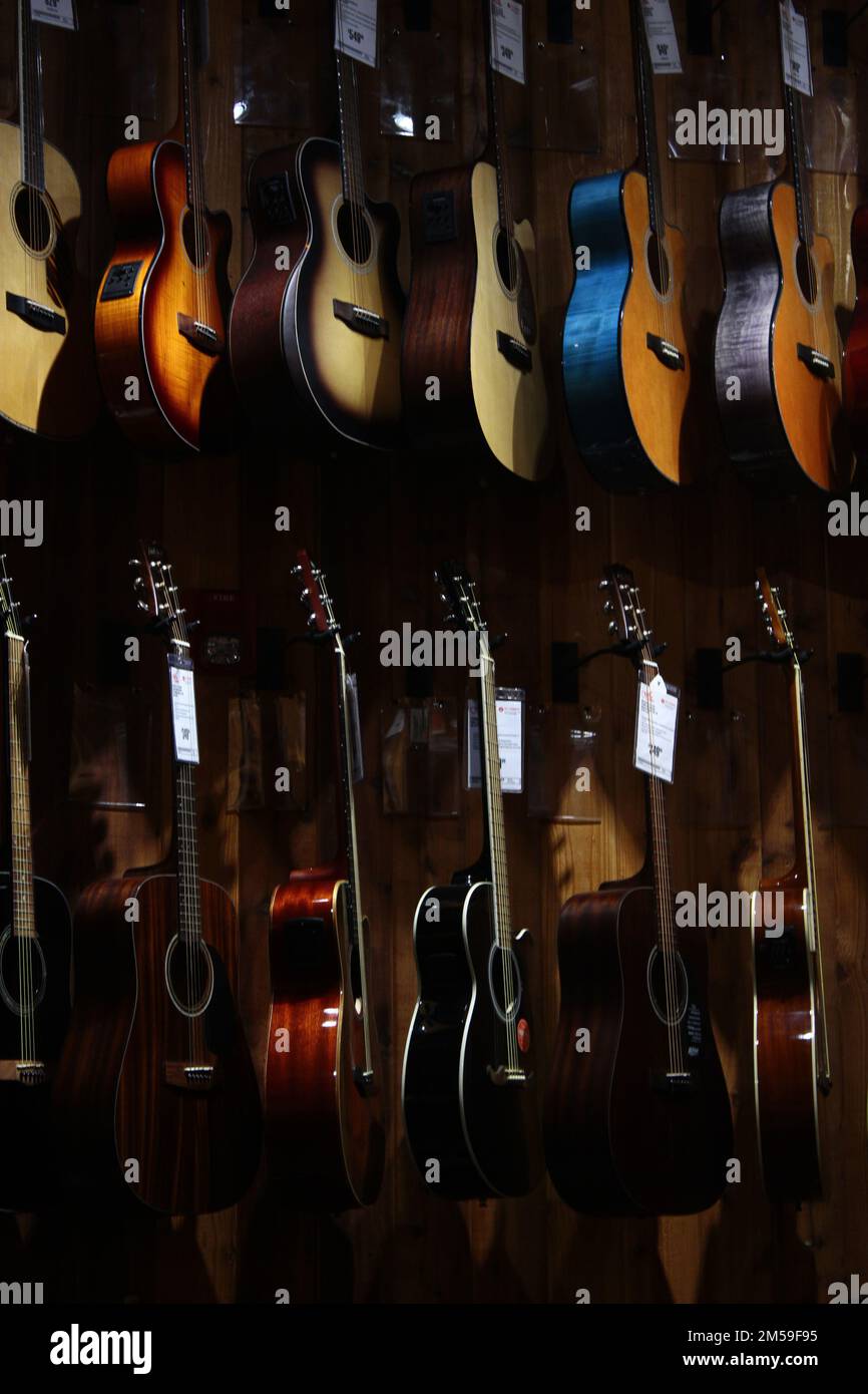 A collection of acoustic guitars displayed in the store Stock Photo - Alamy