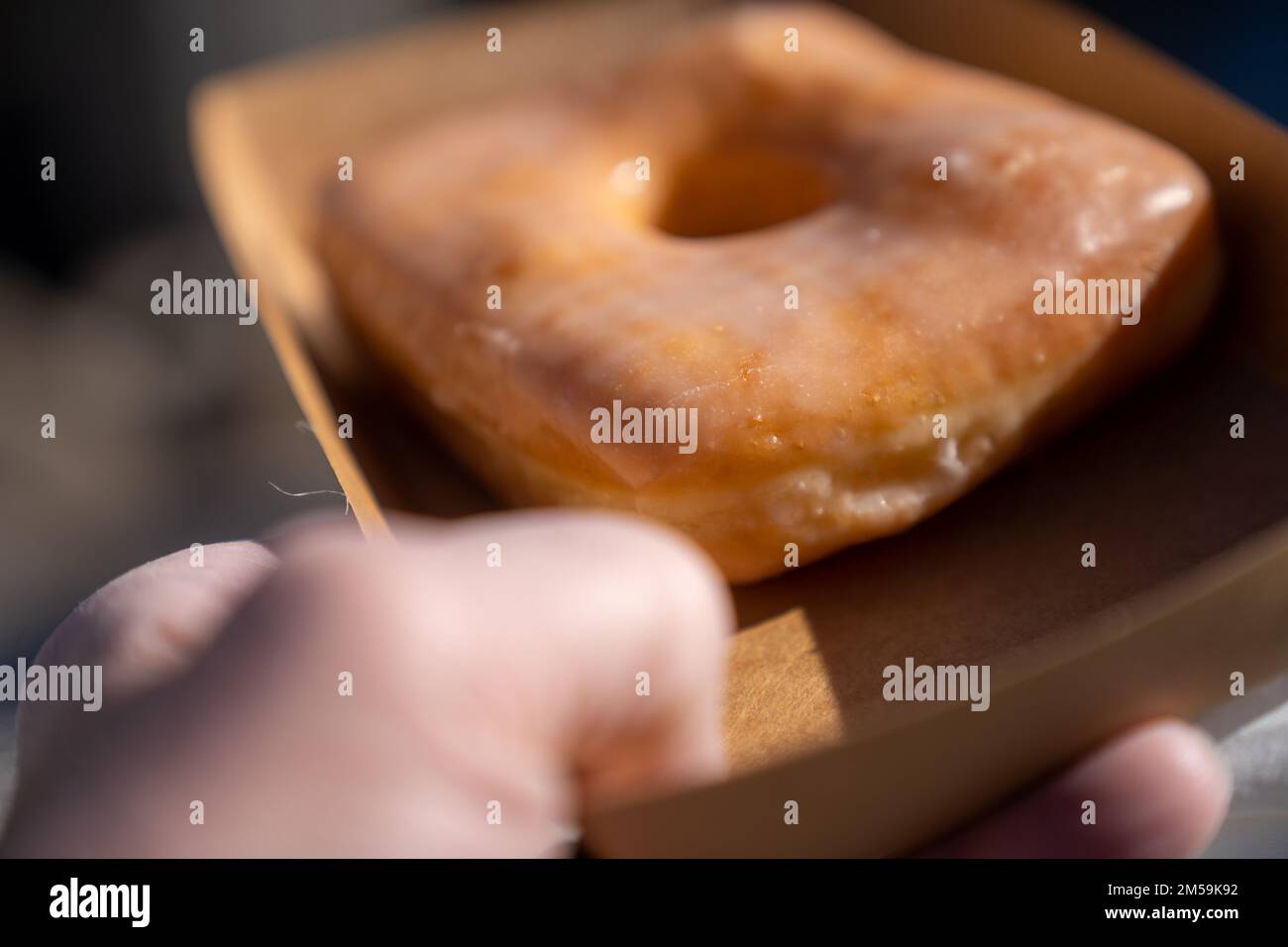 Shallow Depth of field image of a man holding a doughnut Stock Photo ...