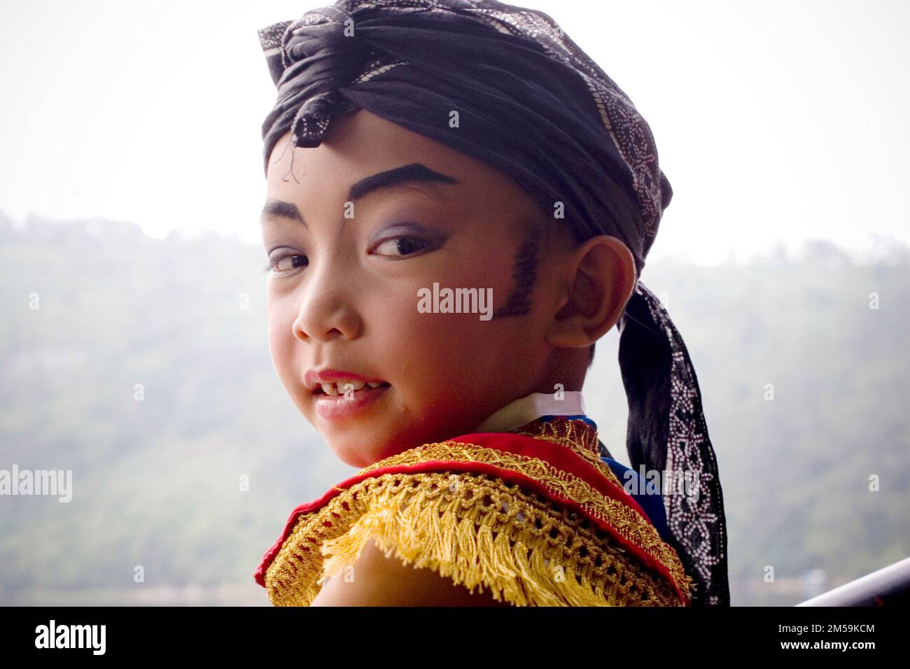 portrait of a little boy with traditional Javanese makeup and clothing ...