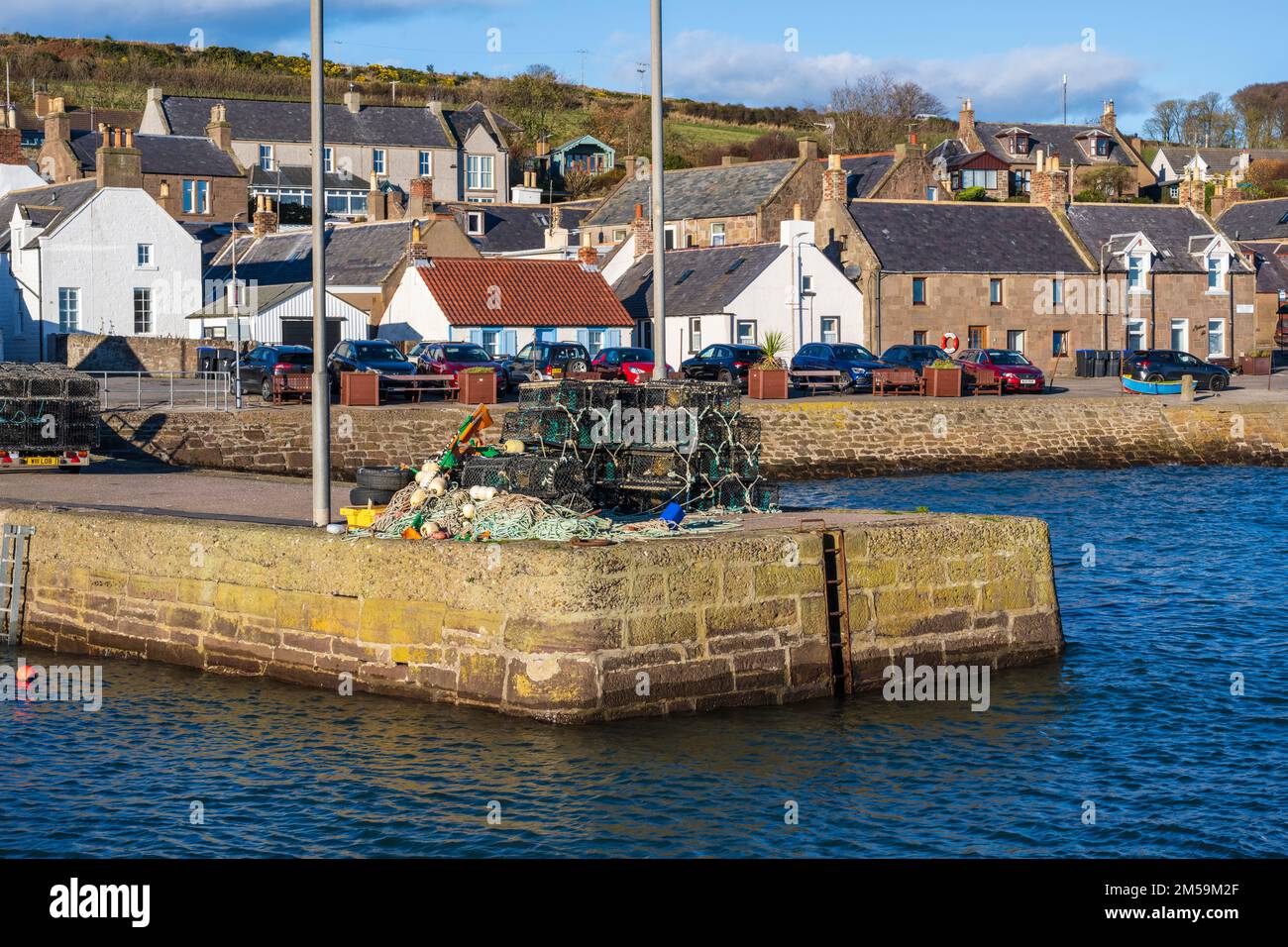 Harbour wall and seafront buildings in coastal village of Johnshaven on ...