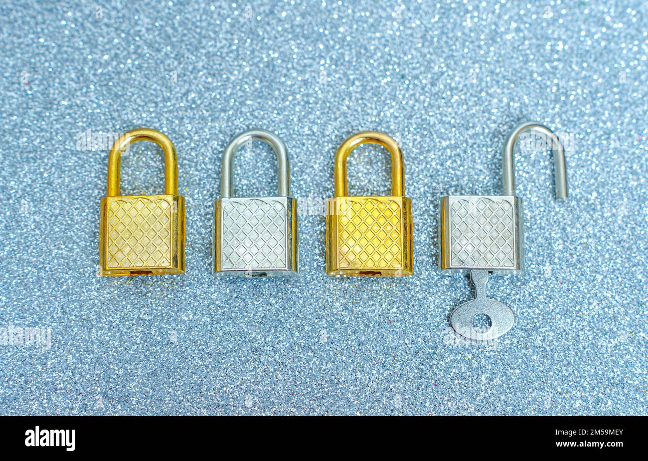 Row of four shiny metal padlocks on a sparkling background. One padlock ...