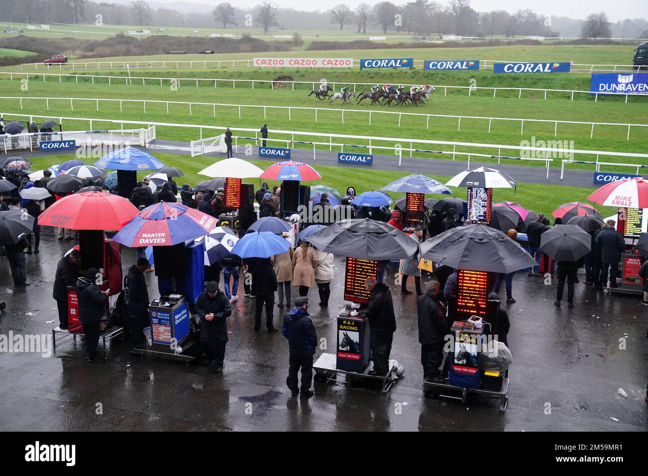 Racegoers and Bookmakers shelter from the rain during the Coral Racing ...