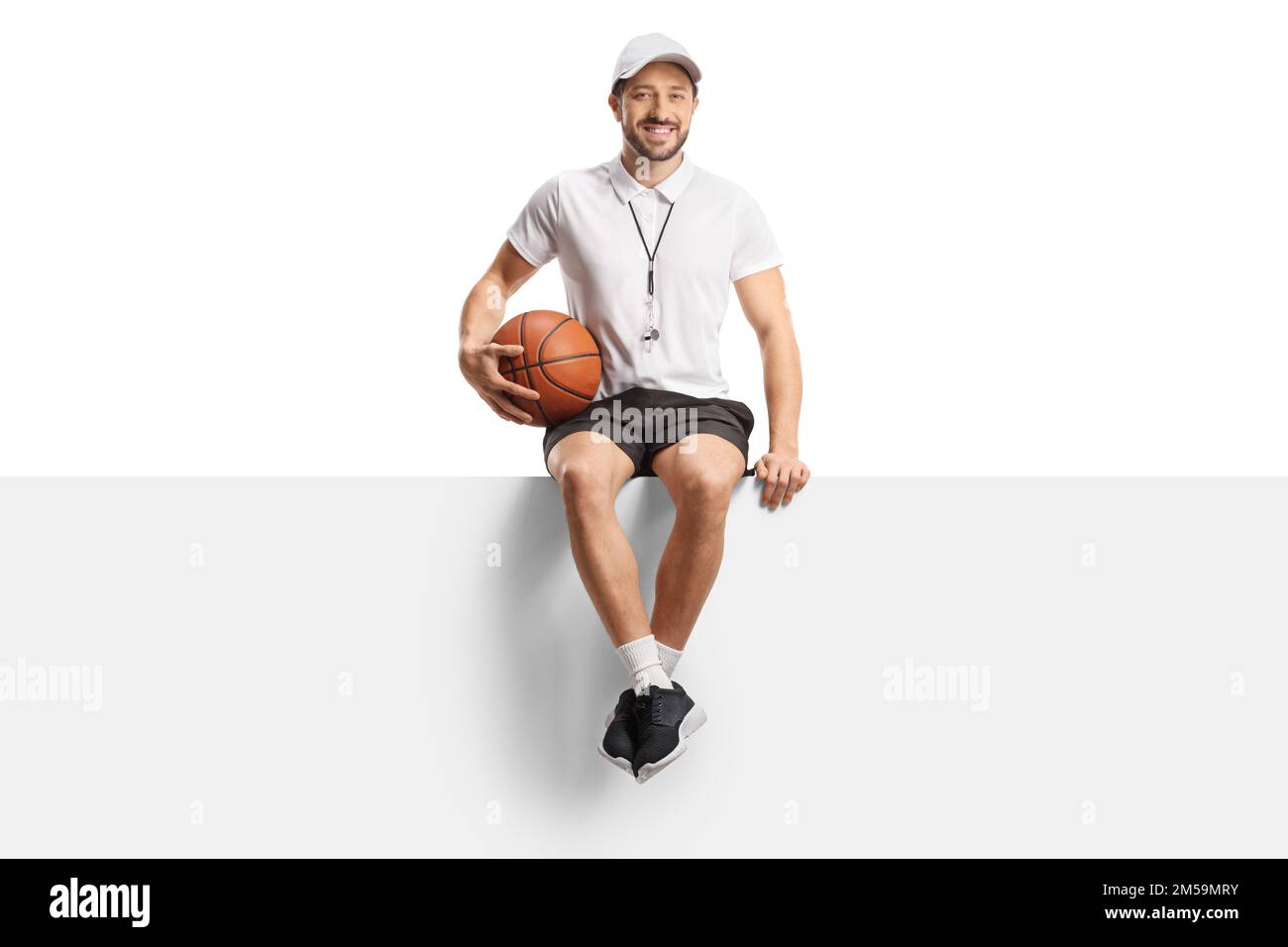 Full length portrait of a sports coach holding a basletball and sitting ...
