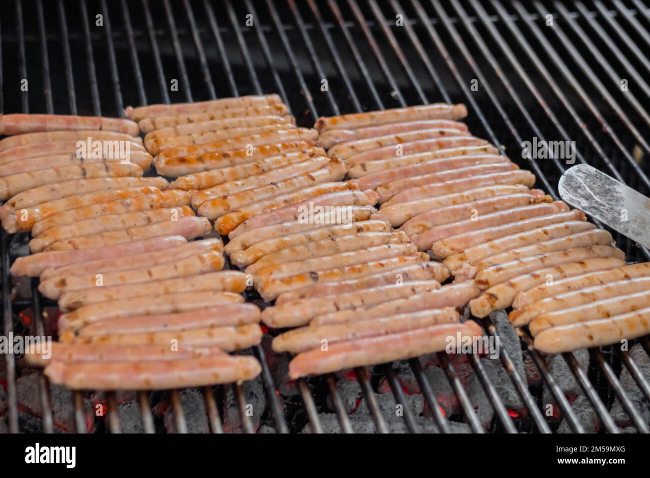 Process of grilling fresh meat sausages on big round grill Stock Photo ...