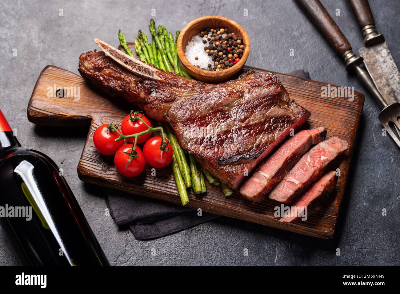 Medium rare grilled Tomahawk beef steak with asparagus Stock Photo - Alamy