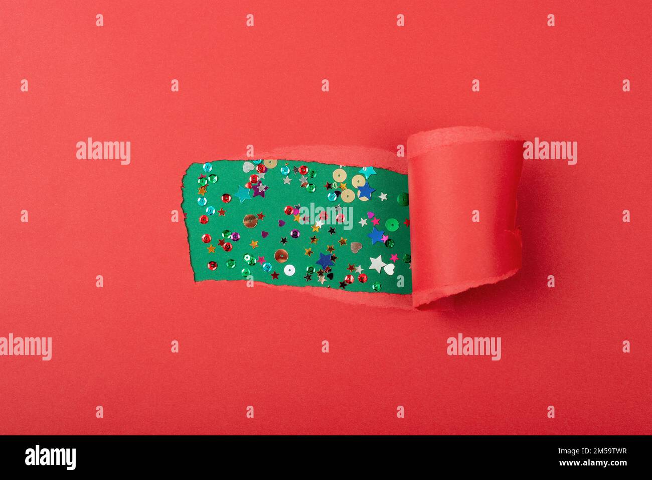 Red torn paper on green background with colorful confetti. Christmas ...