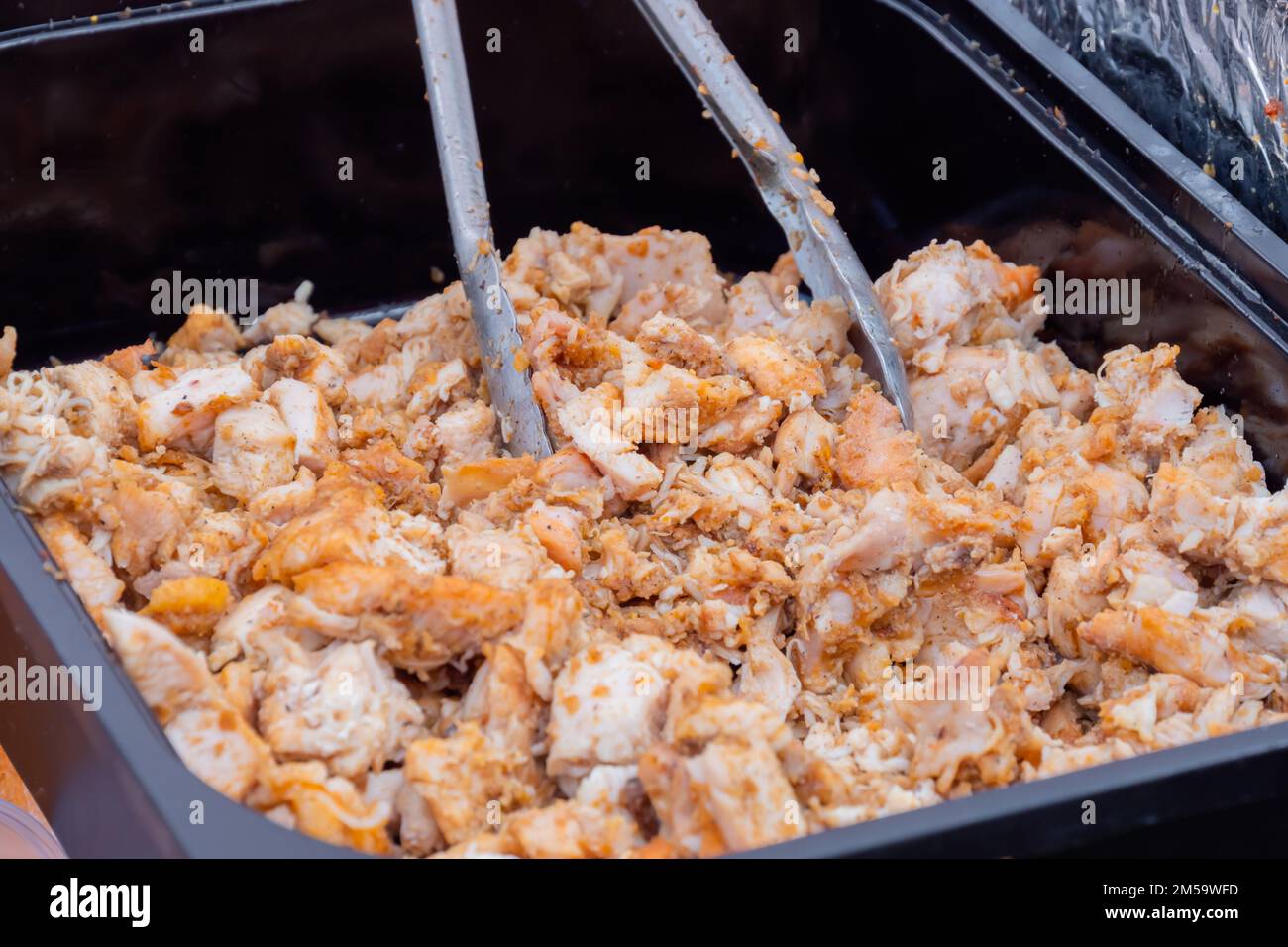 Cooked roasted chicken meat pieces in food container at local food ...