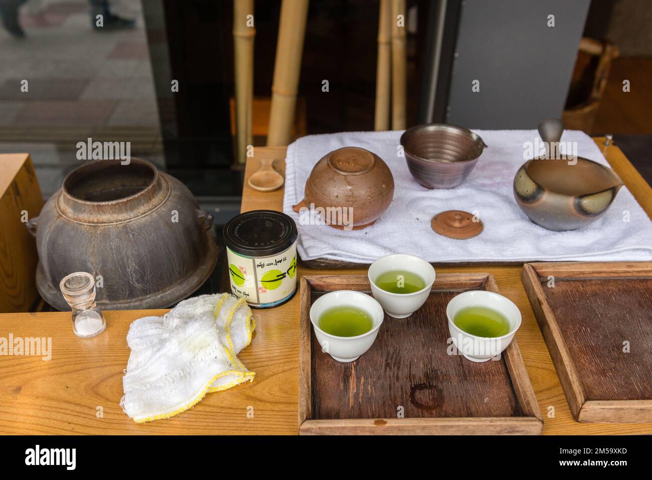 Three white cups of green tea to welcome customers, at a stall inside ...