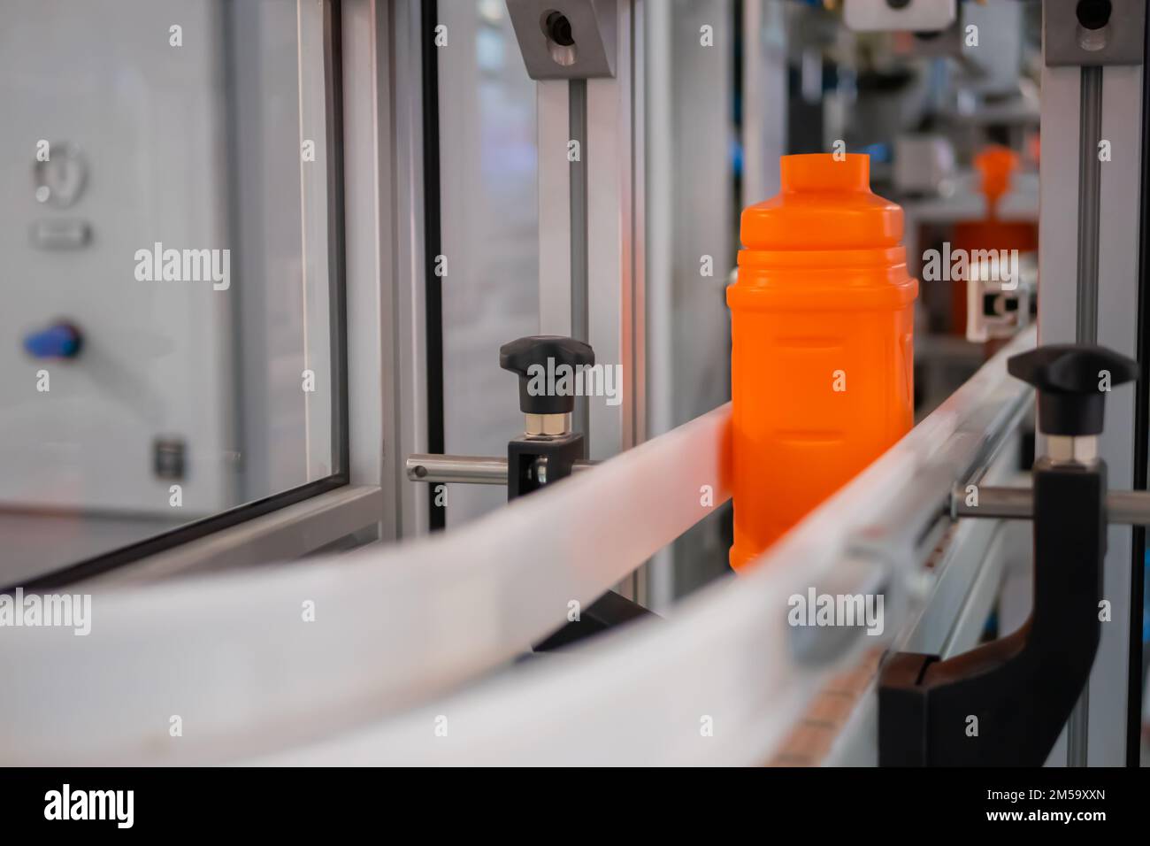 Empty orange plastic jerry can moving on conveyor belt at exhibition ...