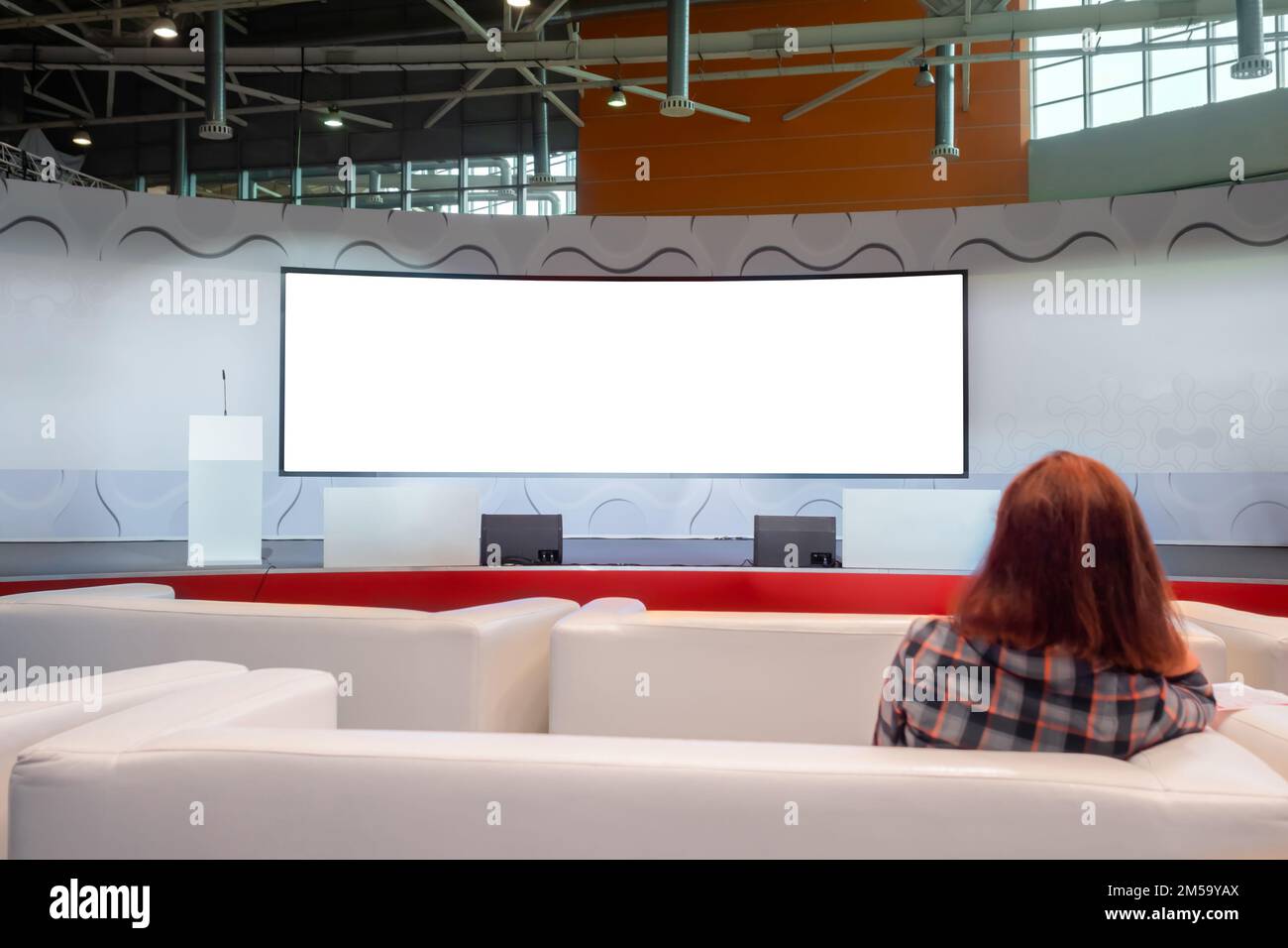 Woman looking at blank wide interactive wall display - white screen ...