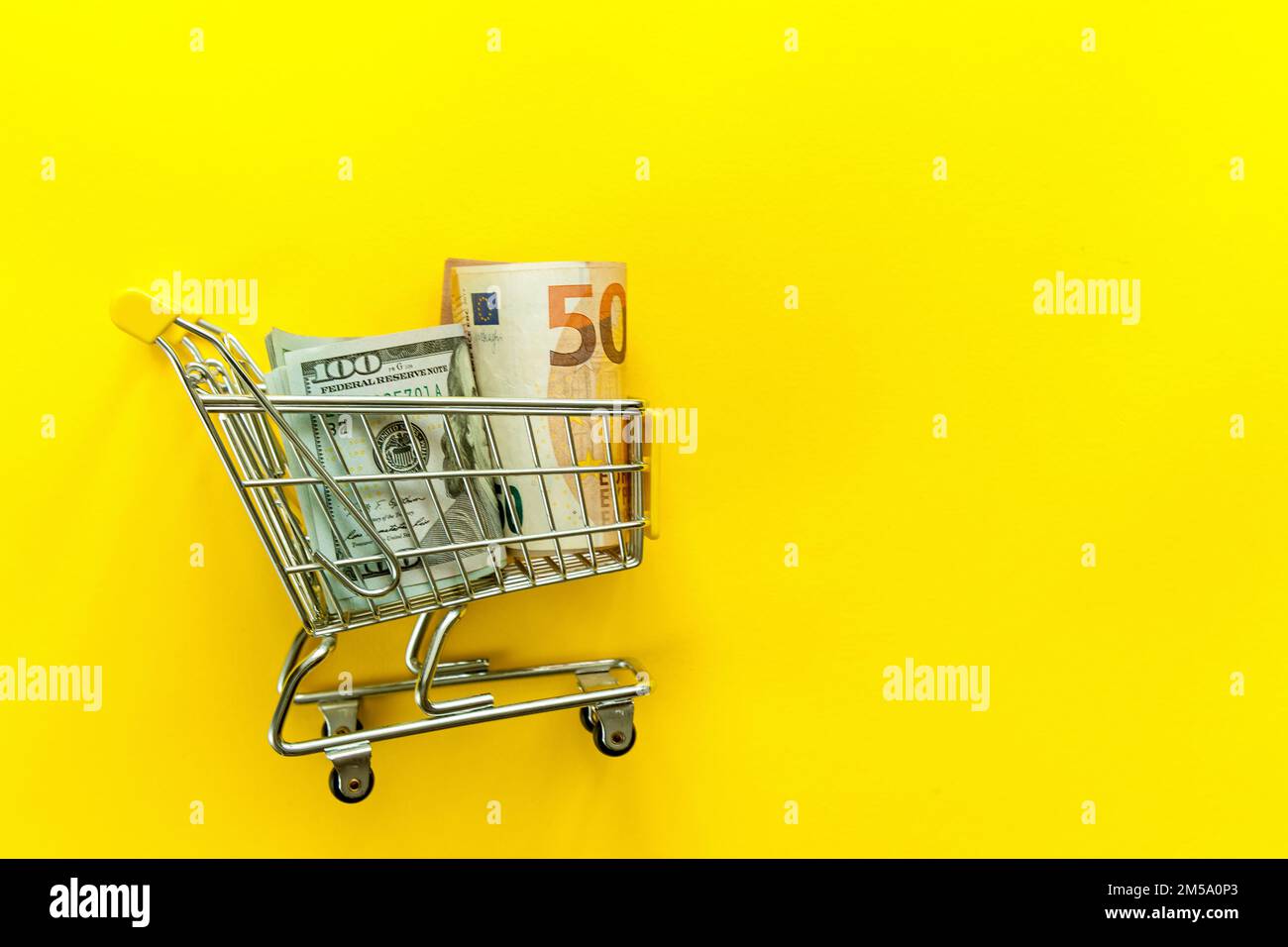 Paper banknotes in a metal trolley on a yellow background Stock Photo ...