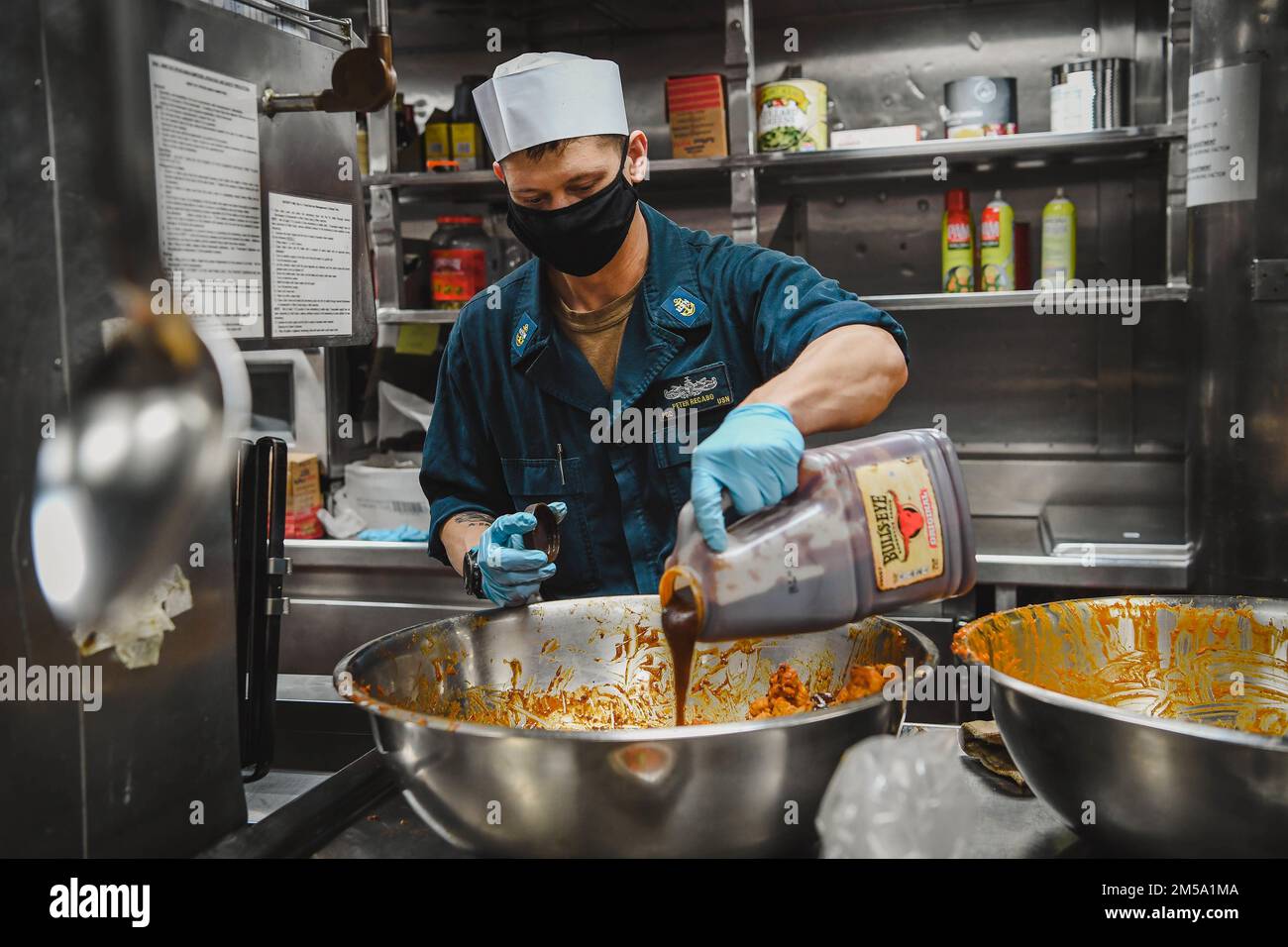 Fire Controlman Chief Petty Officer Peter Recabo prepares food for a ...