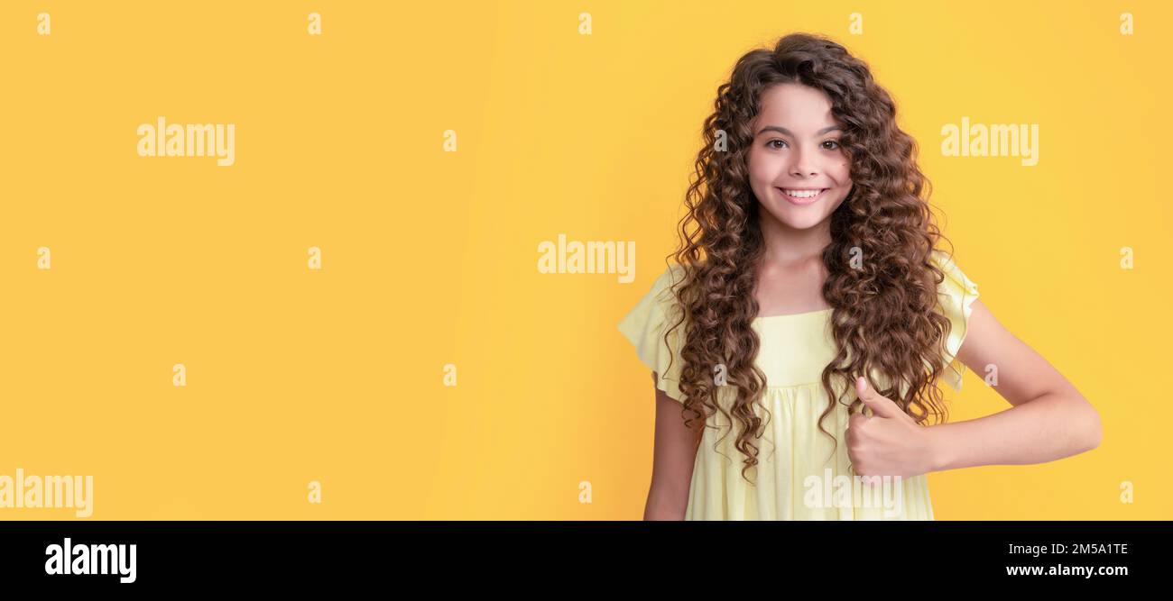 thumb up. smiling kid with curly hair. teen beauty hairstyle. female ...